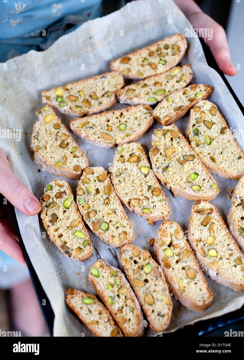 Biscotti. Pistachio flavoured home baked biscuits on a hand held baking ...