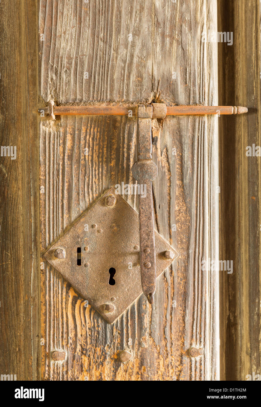 Detail of iron rusty metal door lock and bar on grained wood door Stock ...