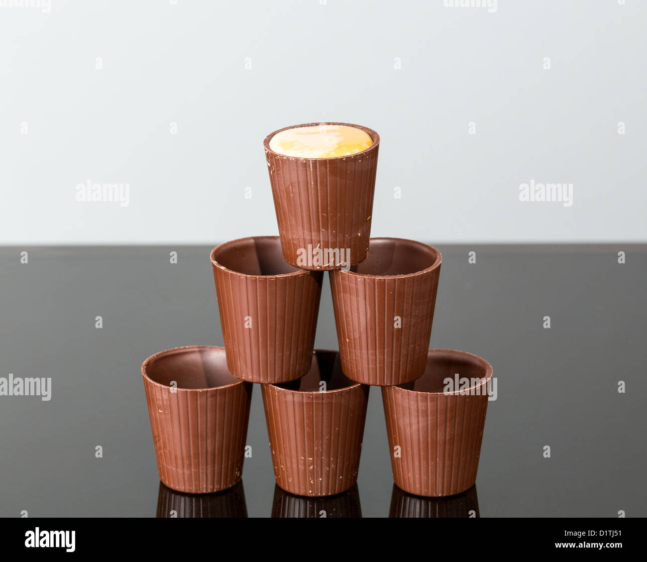 Stack of chocolate shot glasses in pyramid with irish cream poured into ...