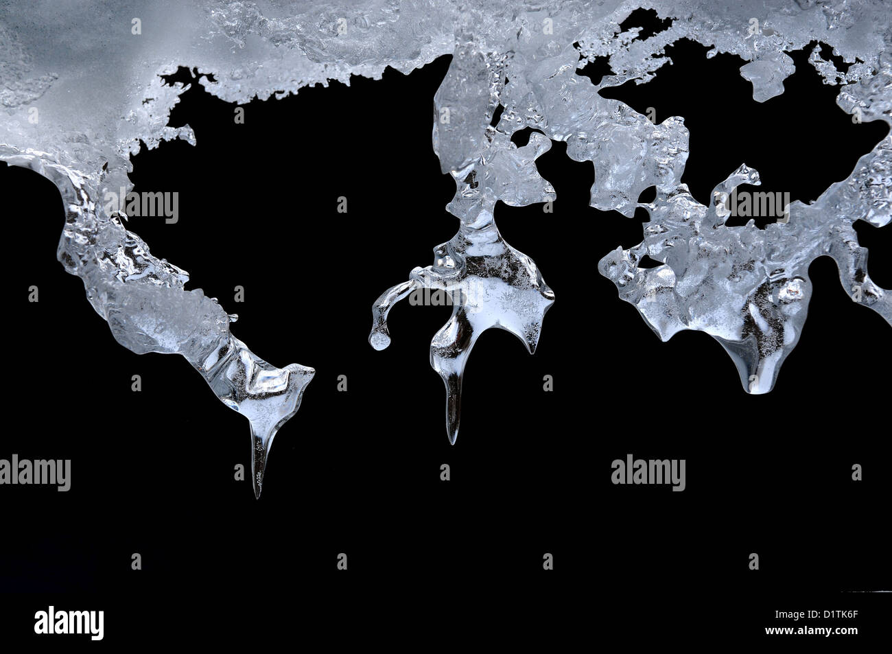 World map carving on icicles in cold light shining in the darkness at ...