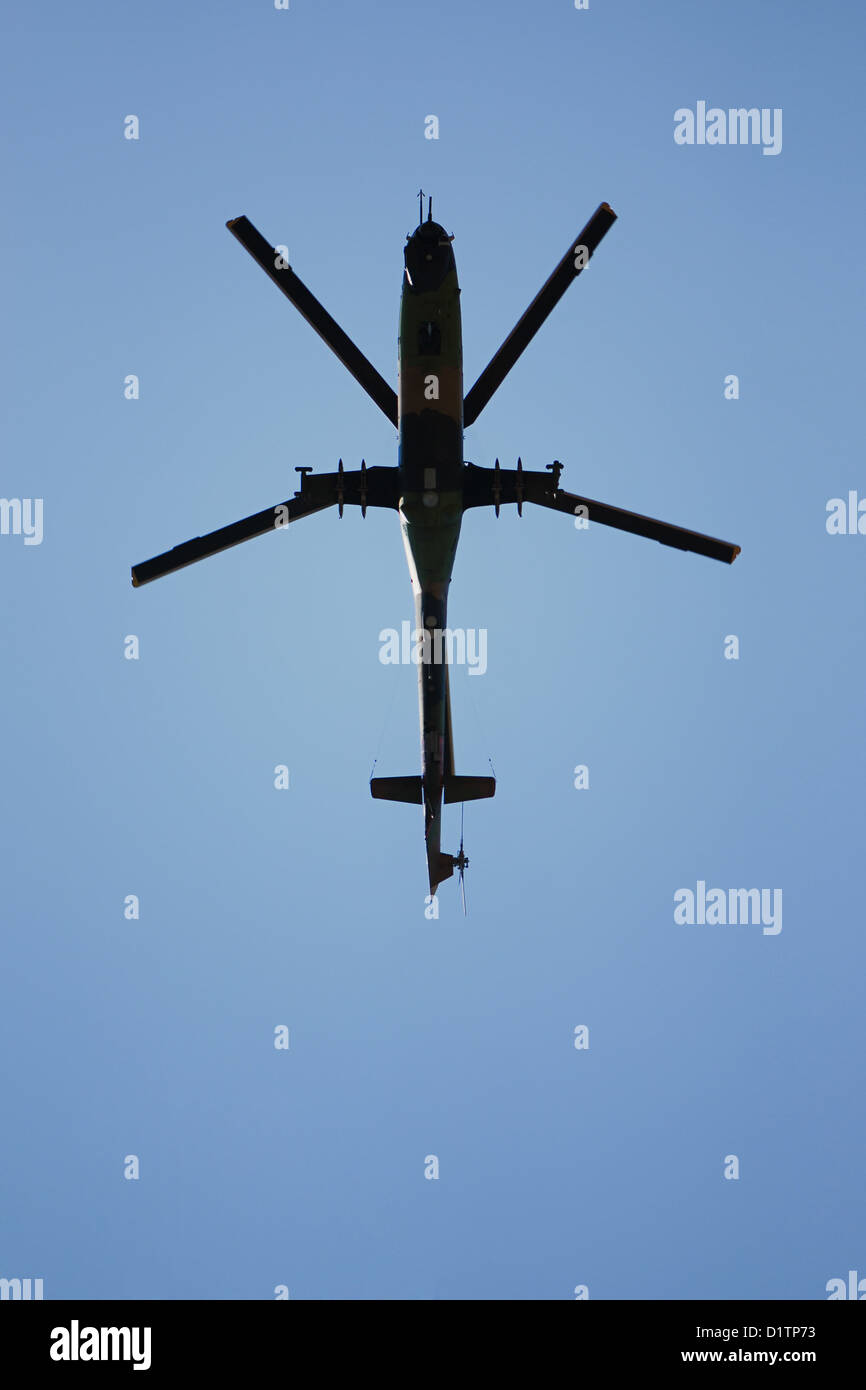 Helicopter passing overhead isolated on blue sky Stock Photo - Alamy