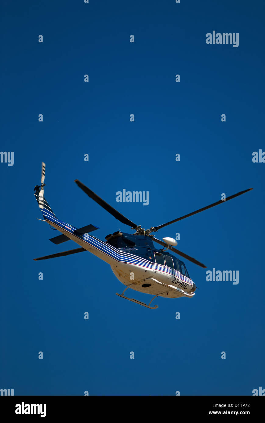 Blue and White chopper in flight isolated on blue sky Stock Photo - Alamy