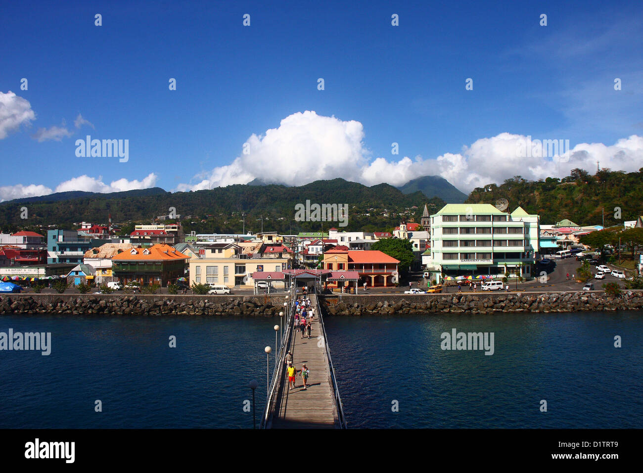 Colorful buildings of Rosseau, Granada from the sea with people on pier ...