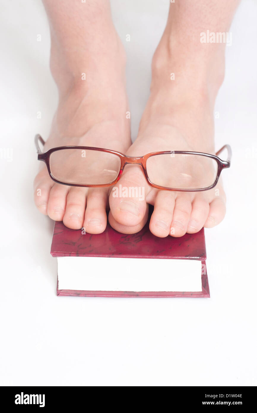 Person standing on a stack of books Stock Photo - Alamy
