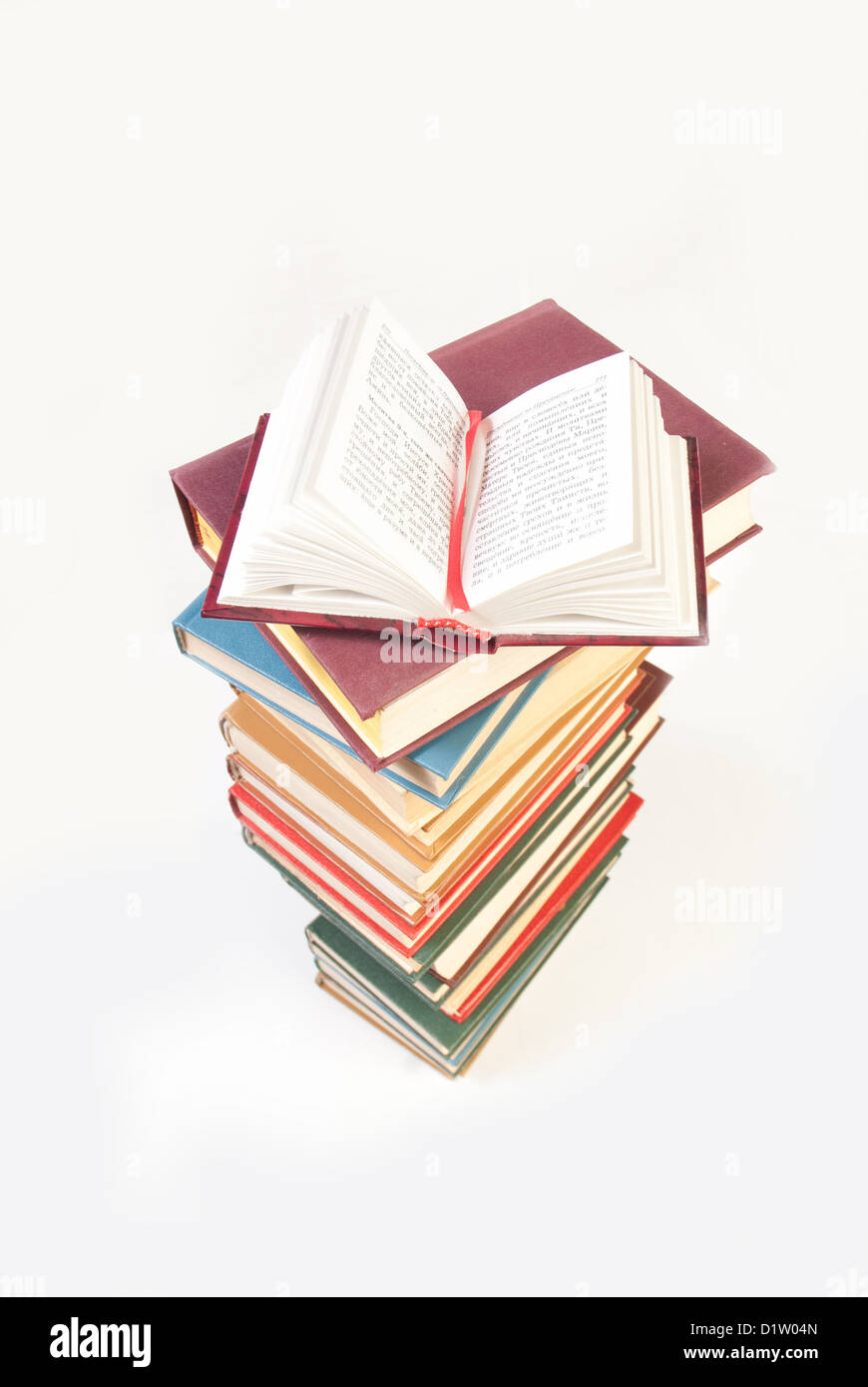 pile of books with one book open on white background Stock Photo - Alamy