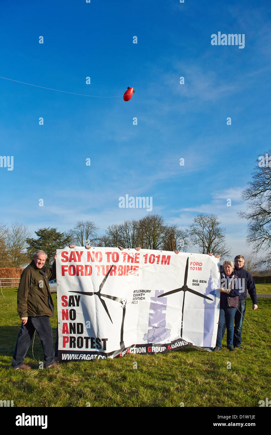 Protesters against a wind turbine proposal hold a banner while flying a ...