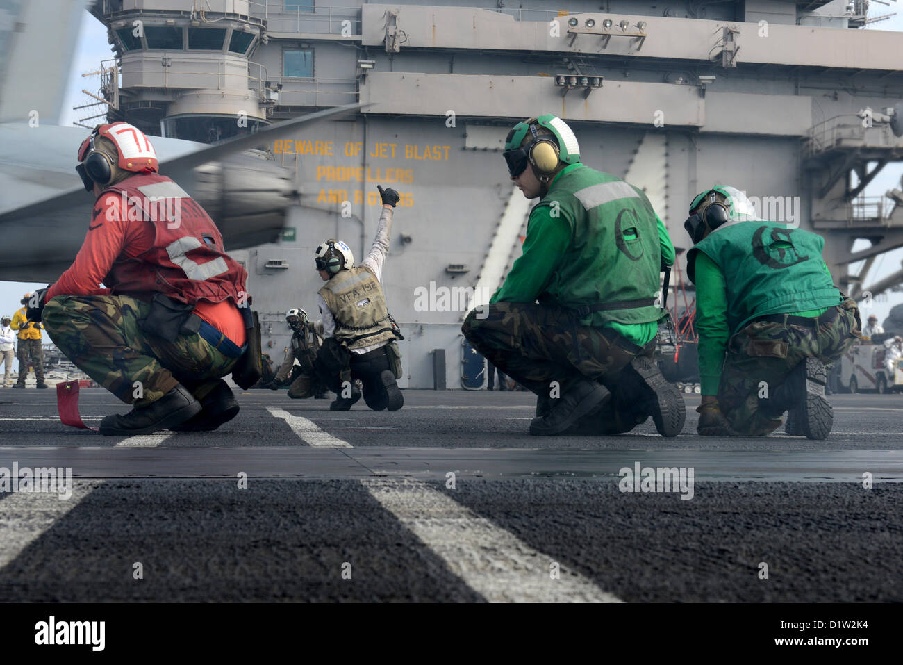 A "shooter" (catapult/arresting gear officer) signals for the launch of ...