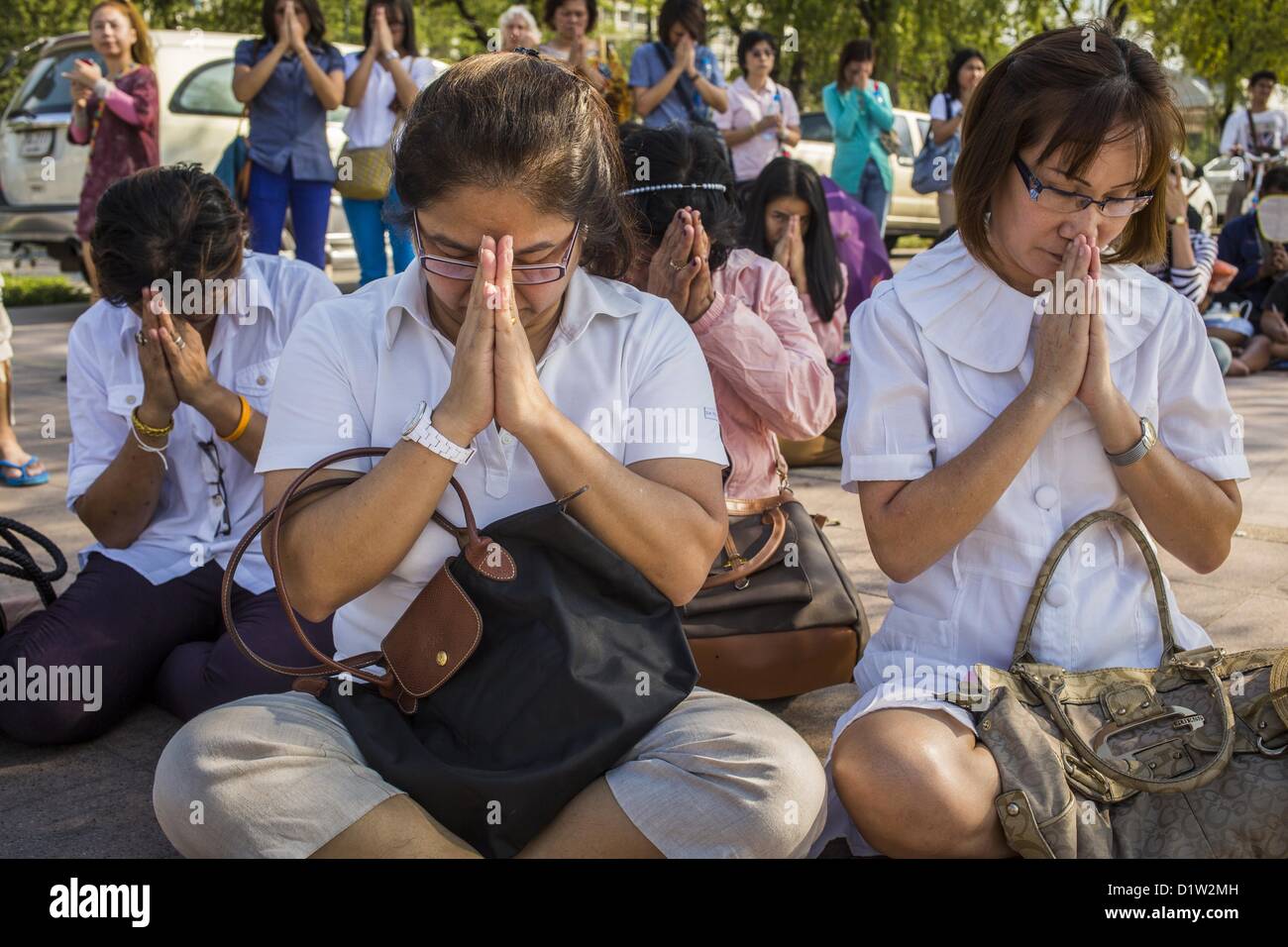 Jan. 6, 2013 - Bangkok, Thailand - Women pray on a sidewalk in Bangkok ...