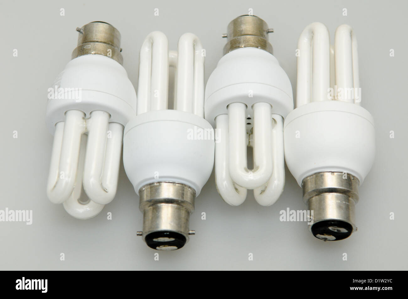 Four energy efficient light bulbs in a row on a white background Stock ...