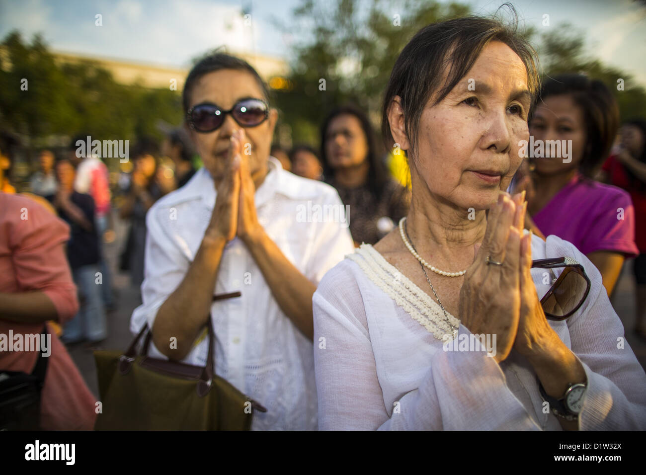 Jan. 6, 2013 - Bangkok, Thailand - Women pray on a sidewalk in Bangkok ...