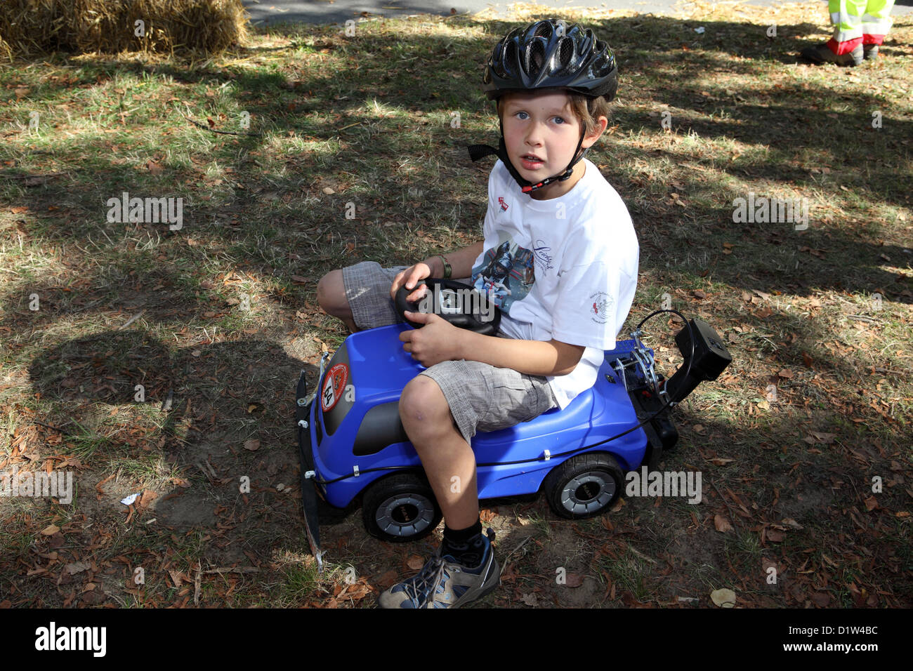 Neuenhagen, Germany, boy sitting on a powered screwdriver with bobby ...