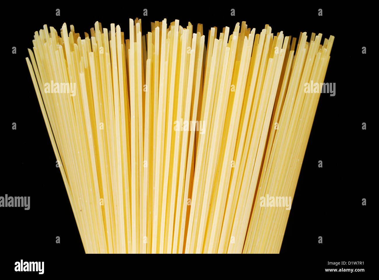 Uncooked spaghetti close up isolated on black Stock Photo - Alamy