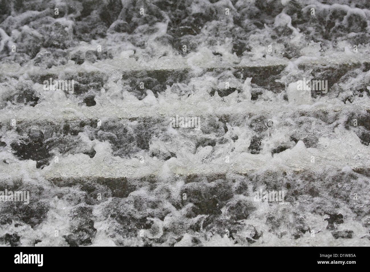 Fast running water running over some stone steps at Marks Hall in Essex ...