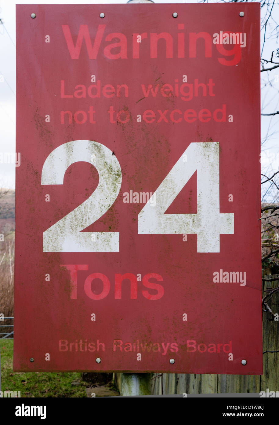 Faded red sign with white writing warning of maximum laden weight of 24 ...