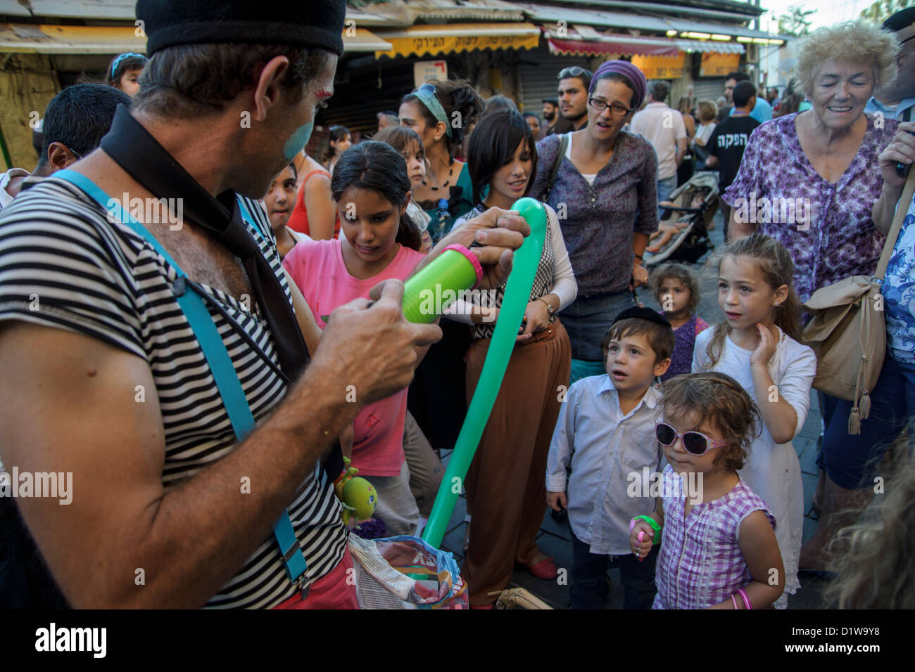Jerusalem, Israel. Crowd looks at a clown performing at the Aug. 2012 ...