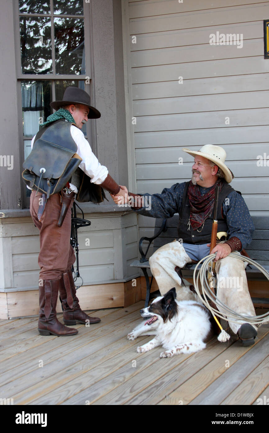 Two cowboys meeting and greet with a handshake Stock Photo - Alamy