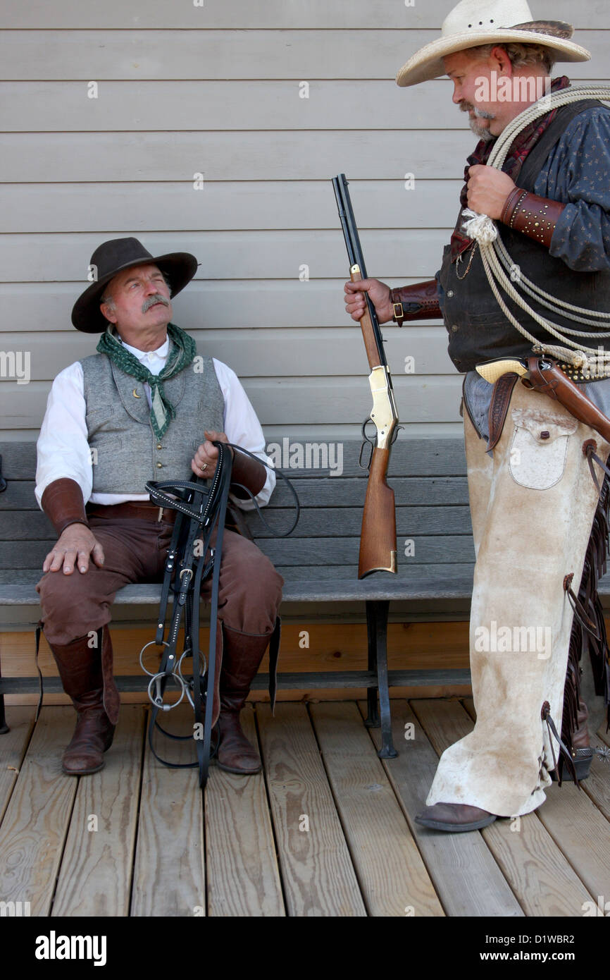 Two cowboys waiting on the train depot platform Stock Photo - Alamy