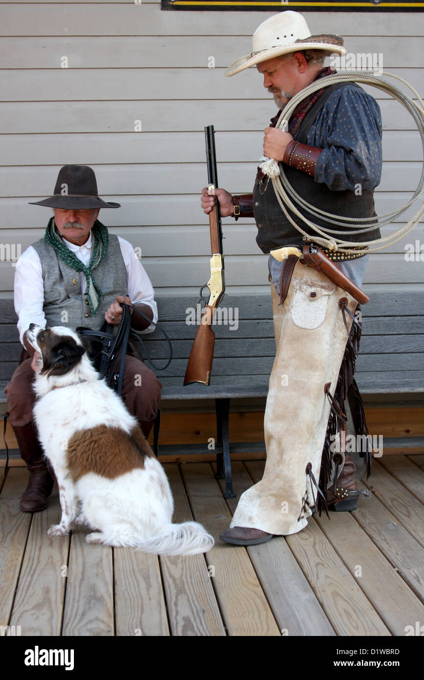 Two cowboys waiting on the train depot platform Stock Photo - Alamy