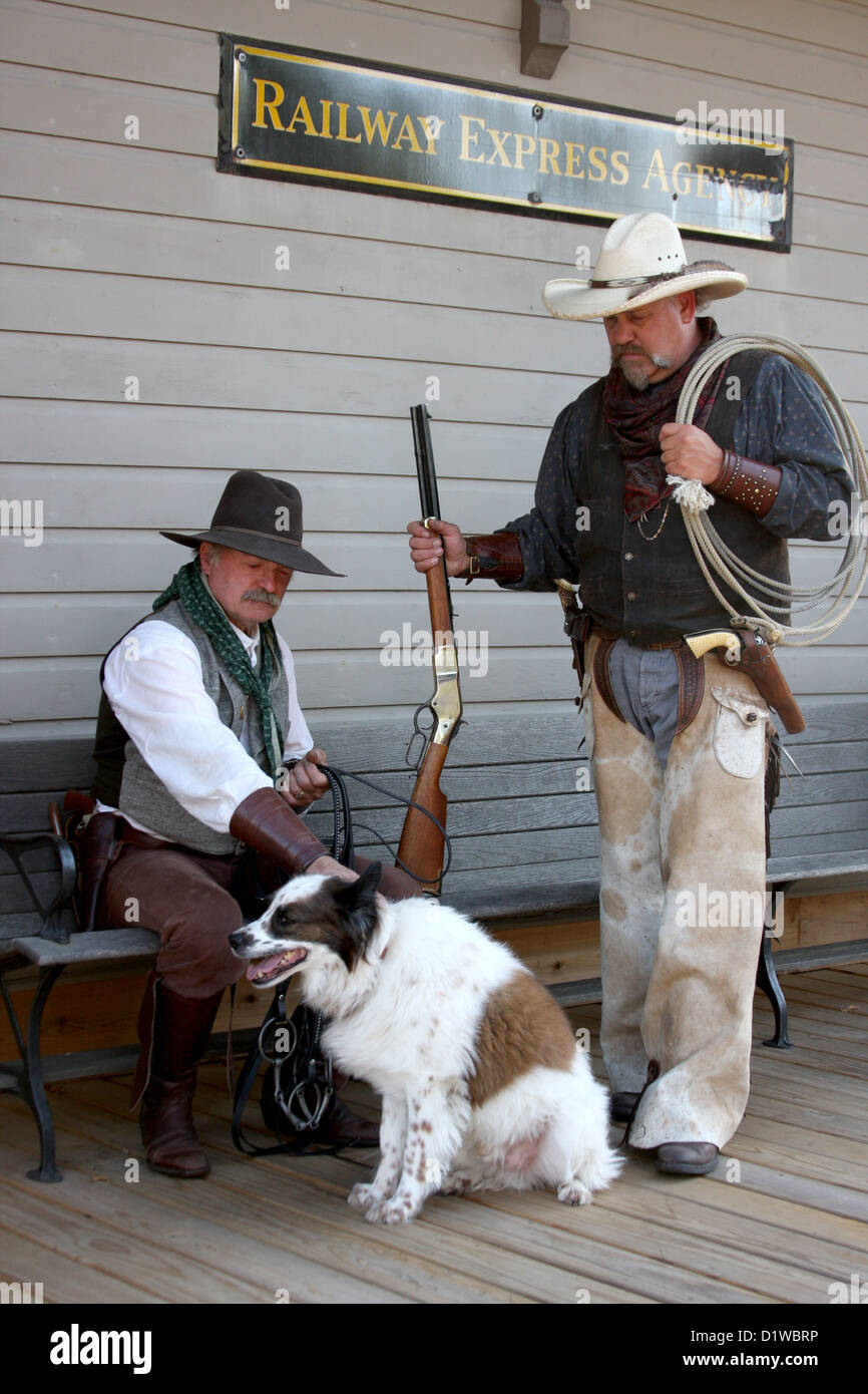 Two cowboys waiting on the train depot platform Stock Photo - Alamy