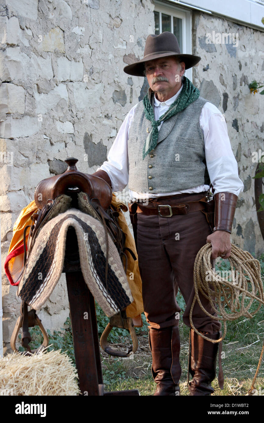 A cowboy standing by his saddle Stock Photo - Alamy