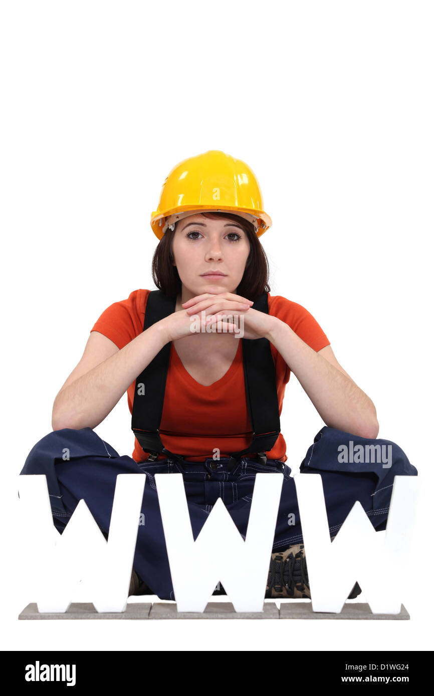 Female builder sat by letters Stock Photo - Alamy