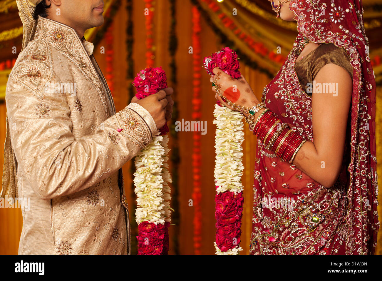Indian bride and groom holding garlands Stock Photo - Alamy