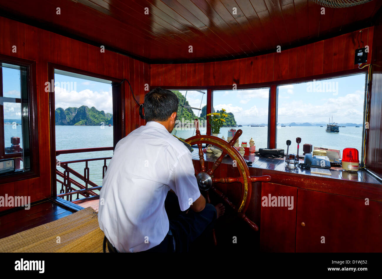 Captain Driving a Boat with Captains Wheel on Traditional Junk, Ha Long ...
