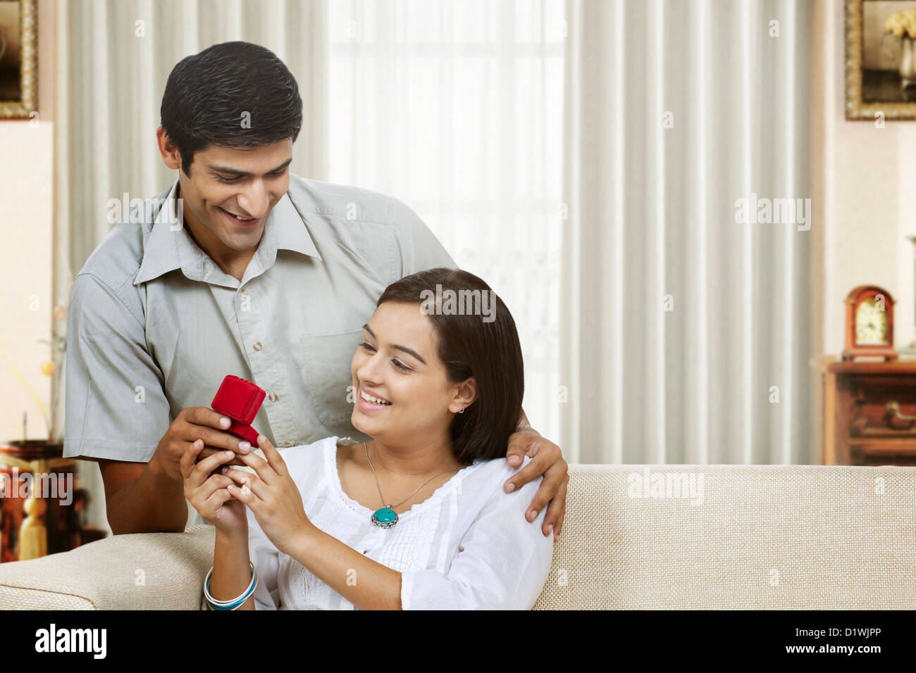 Young man presenting ring as a gift to girlfriend Stock Photo - Alamy