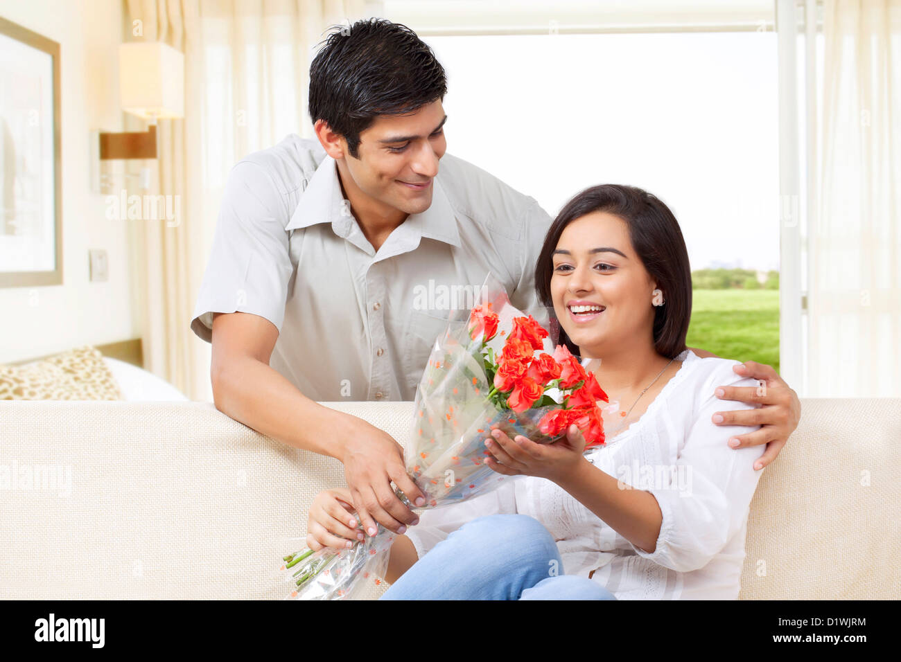 Young man giving flowers to woman Stock Photo - Alamy