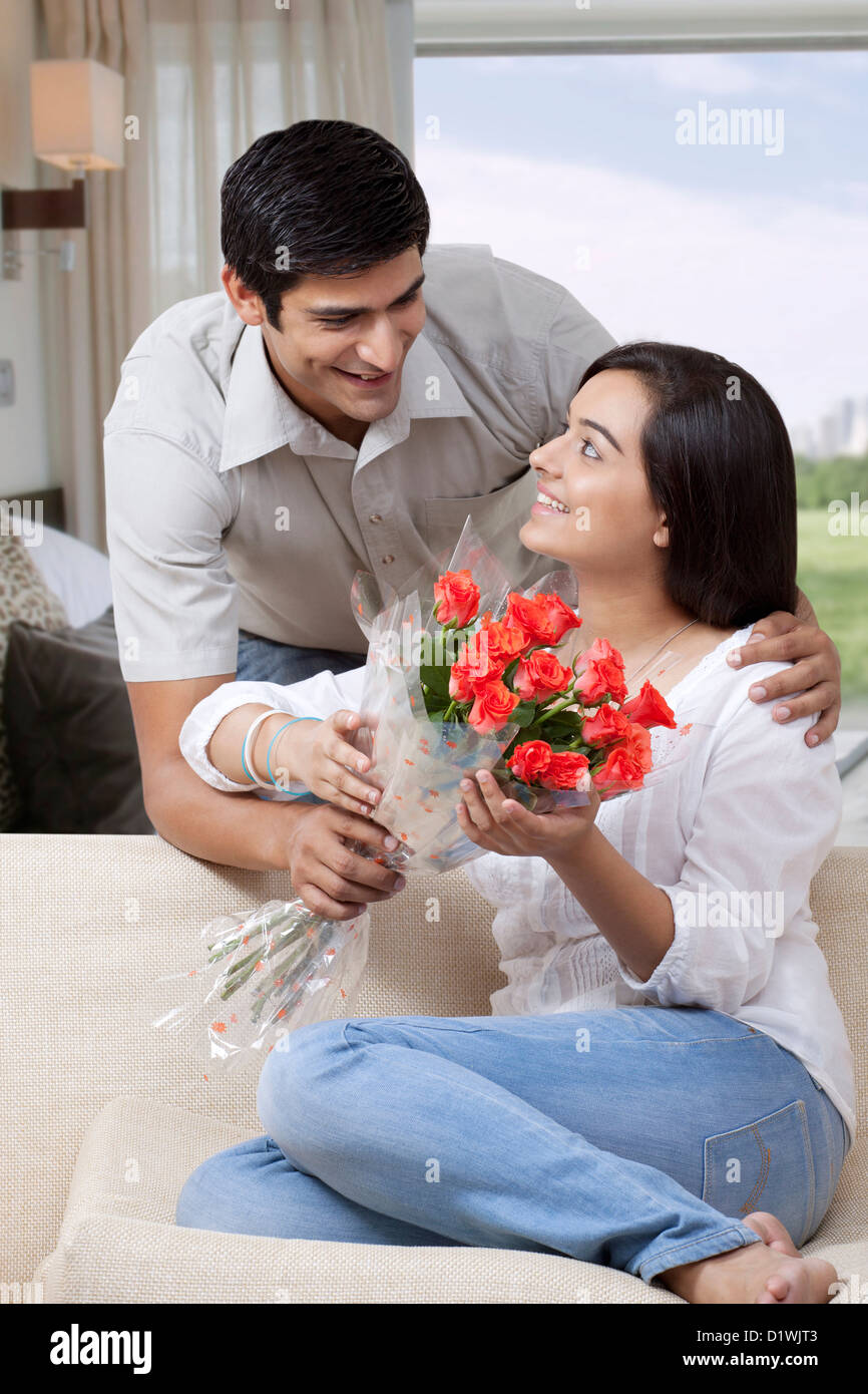 Young man presenting flowers to beautiful woman Stock Photo - Alamy