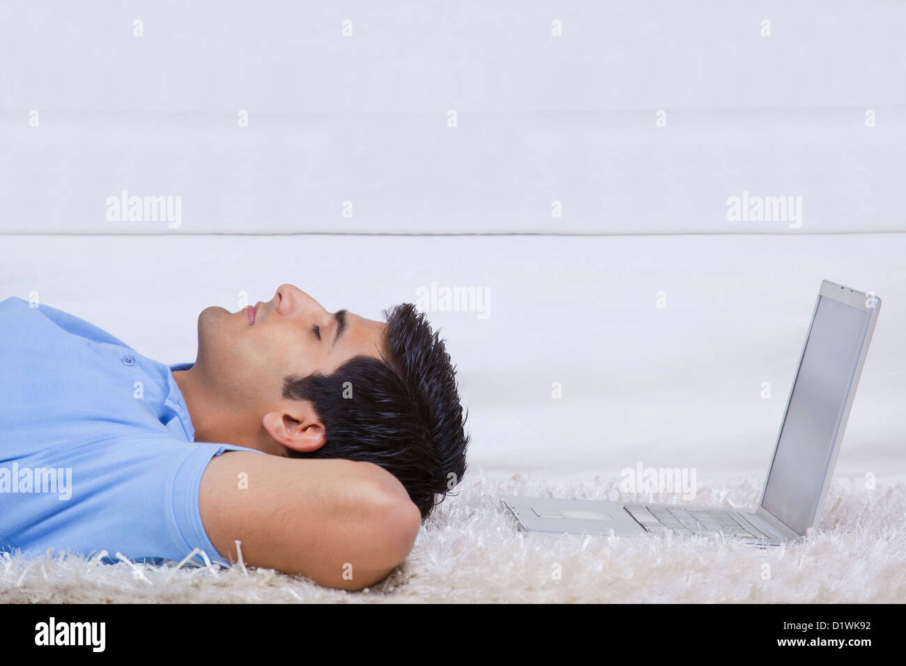 Man lying down in front of laptop Stock Photo - Alamy