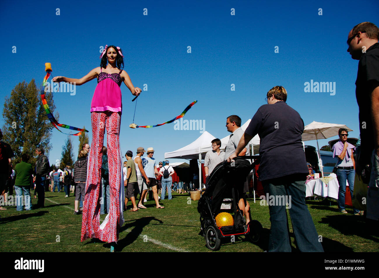 A stilt walker ambles through the fair ground in Mapua Fair Stock Photo ...