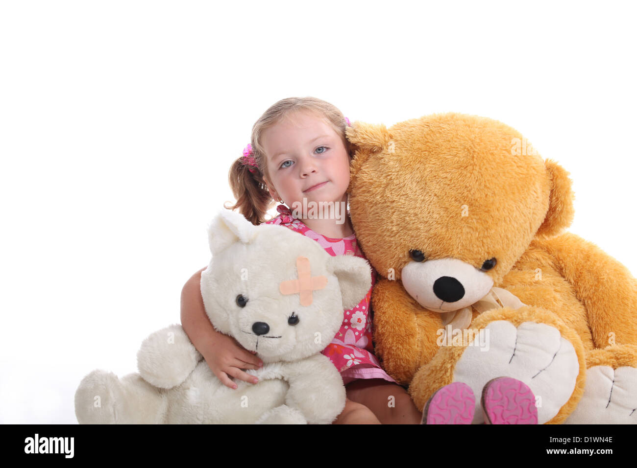 Little girl sat with cuddly toys Stock Photo - Alamy