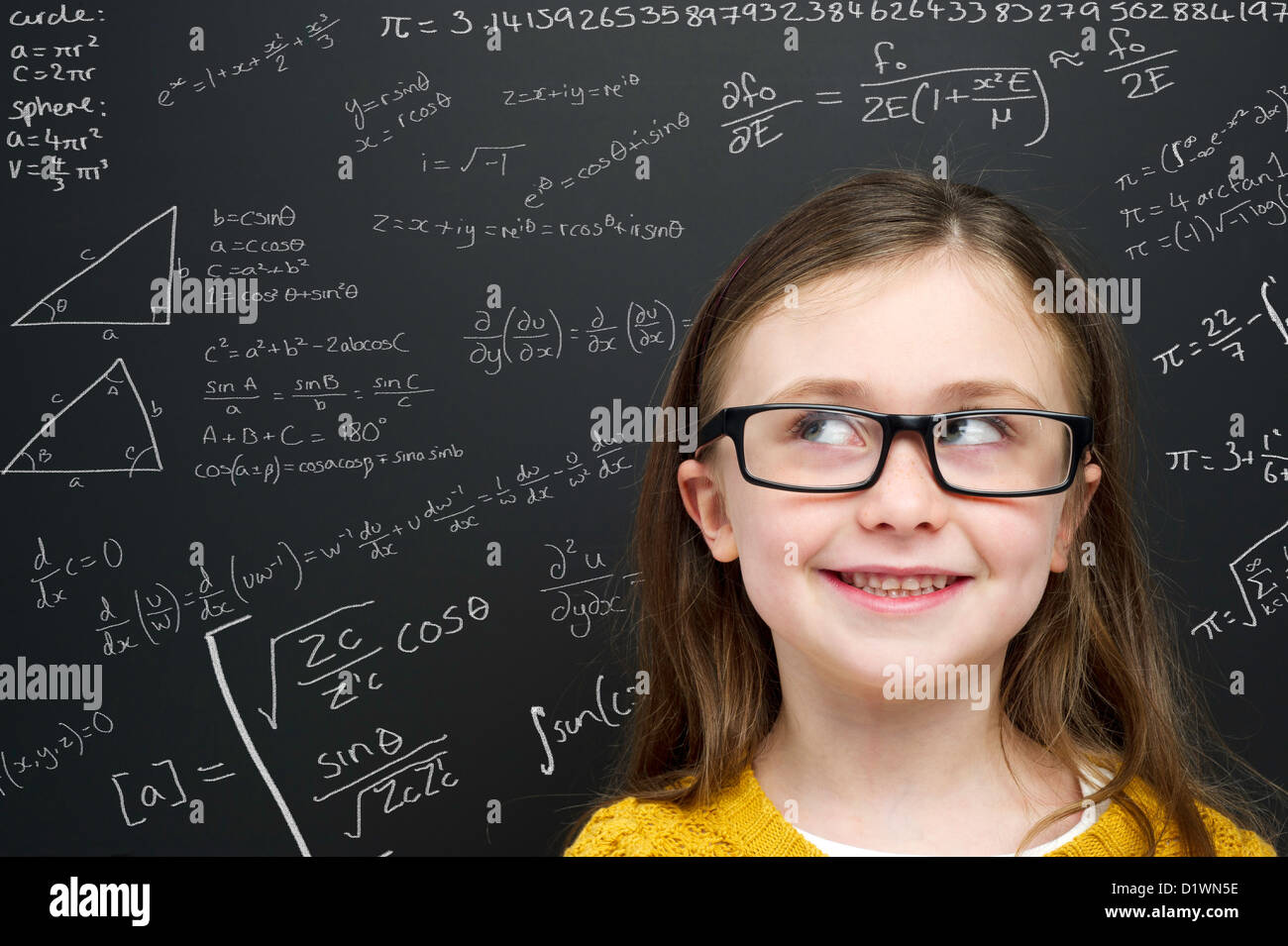 Smart young girl wearing a yellow jumper and glasses stood infront of a ...