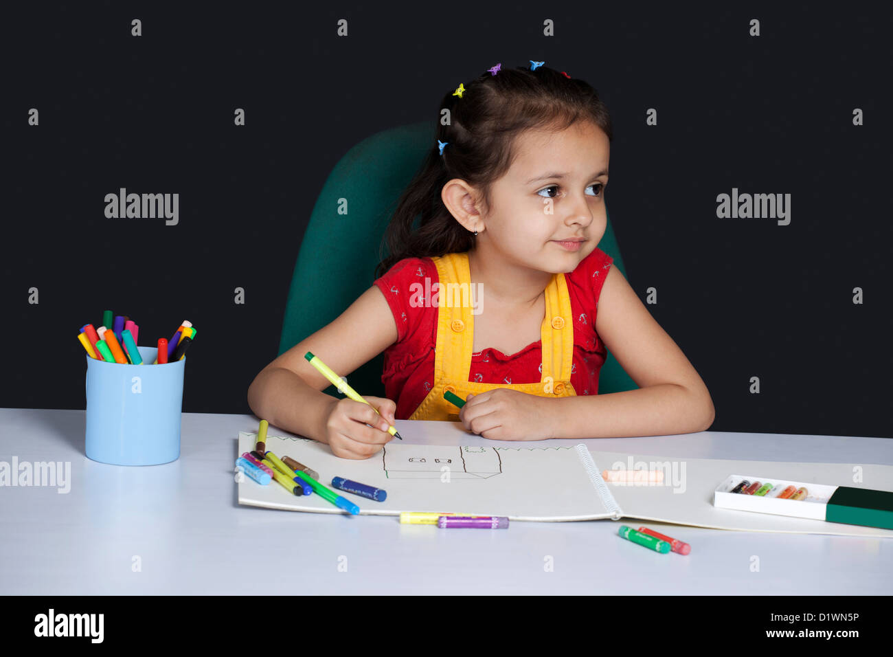 Girl drawing while looking away Stock Photo - Alamy