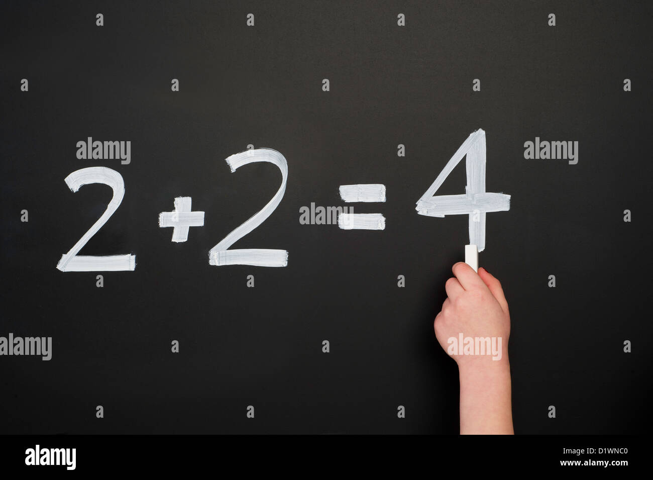 A child's hand drawing 2+2=4 in chalk on a blackboard Stock Photo - Alamy