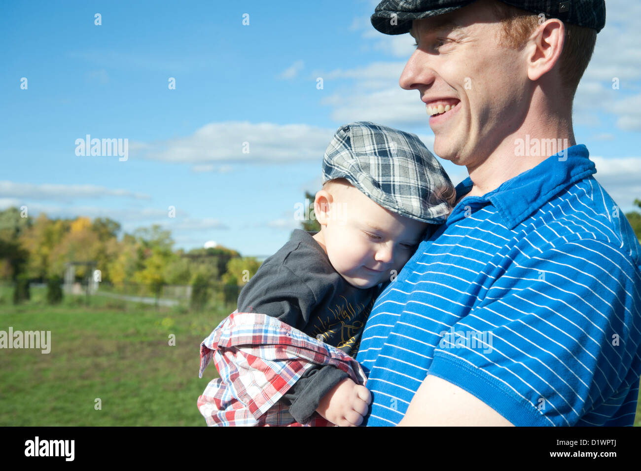Father holding baby against chest with baby leaning into chest ...
