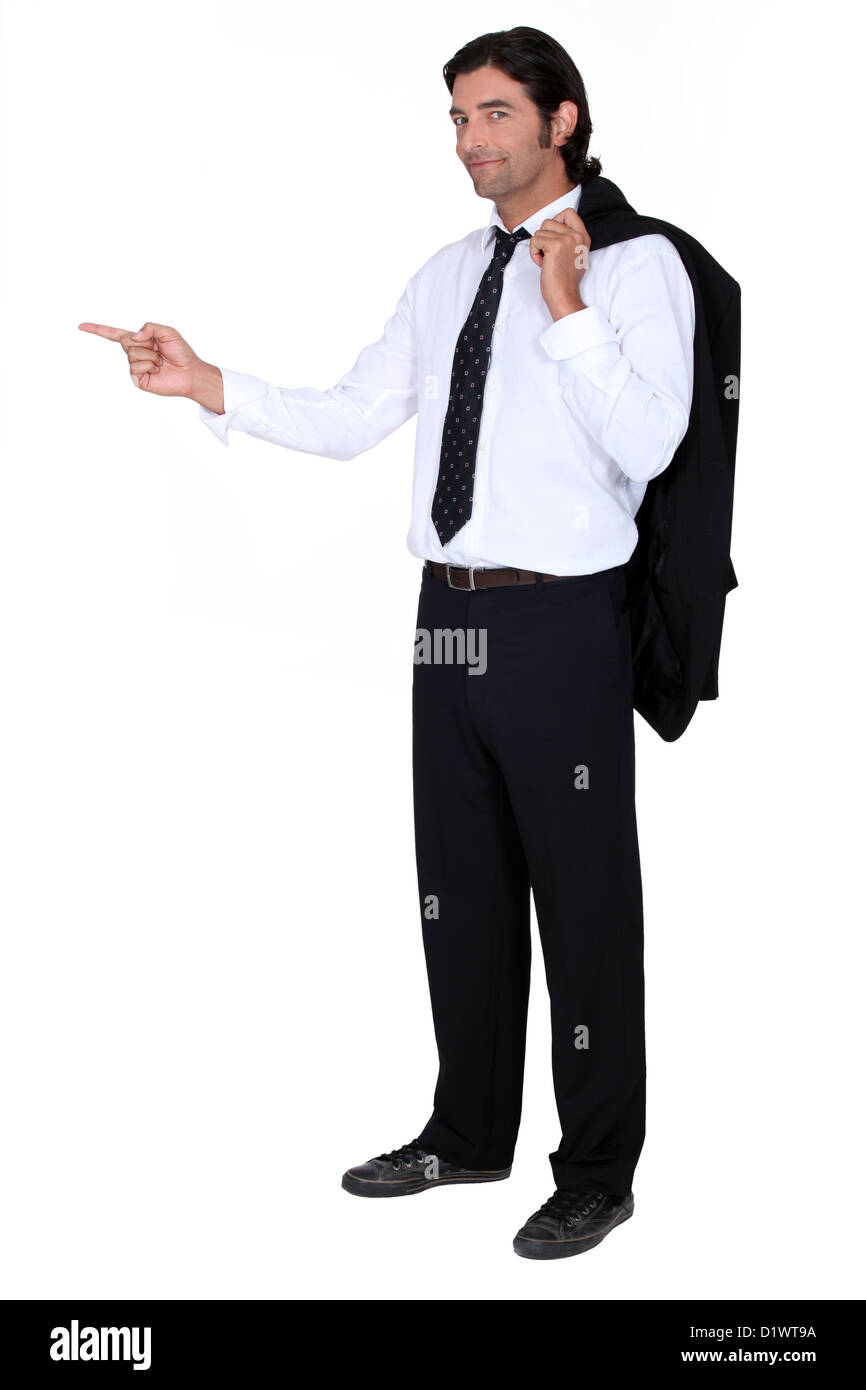 Man with a suit jacket flung over his shoulder pointing at a screen ...