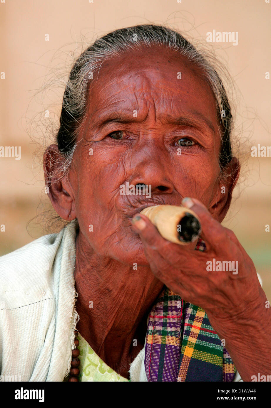 Portrait of a local Burmese woman smoking a large cheroot at a market ...