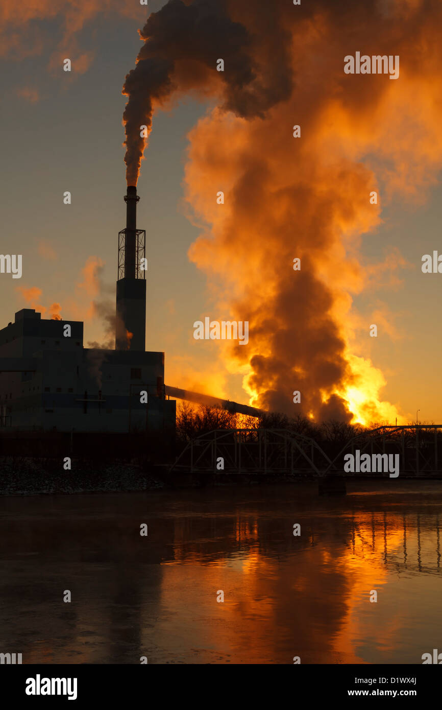 Early morning sun illuminates smoke from a paper mill operation Stock ...