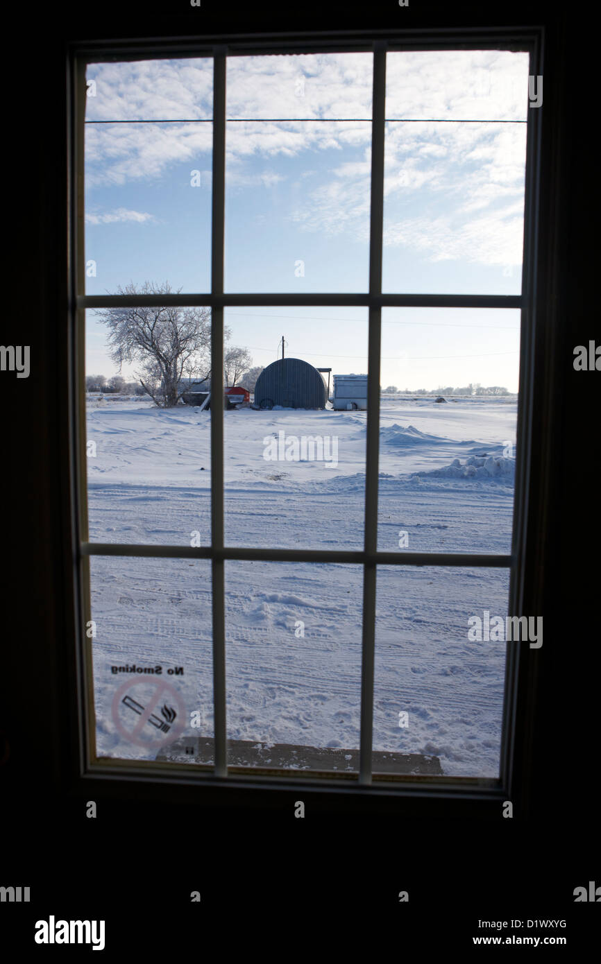 looking out through door window to snow covered scene in small rural ...