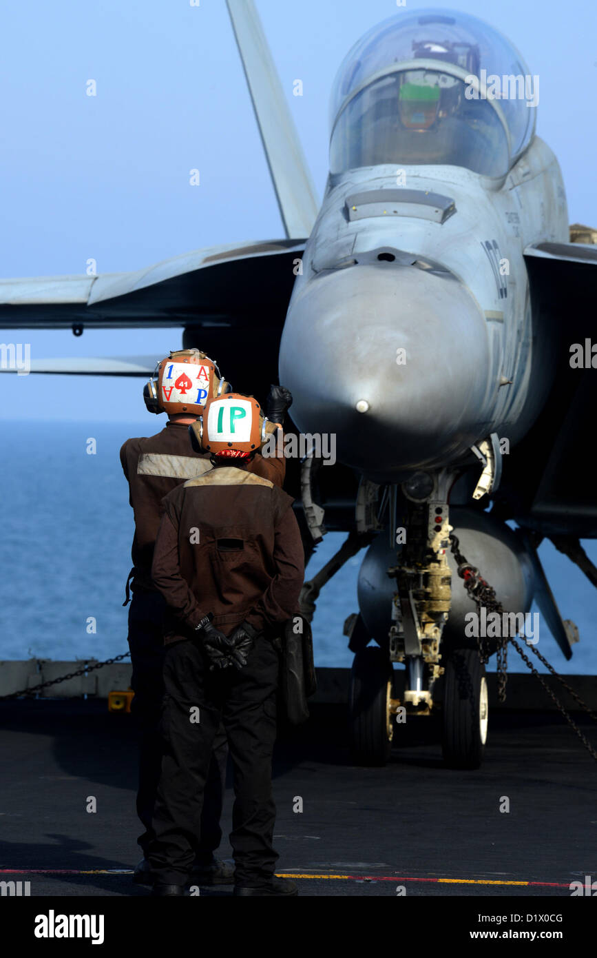 Plane captains signal for the start-up of an F/A-18F Super Hornet from ...