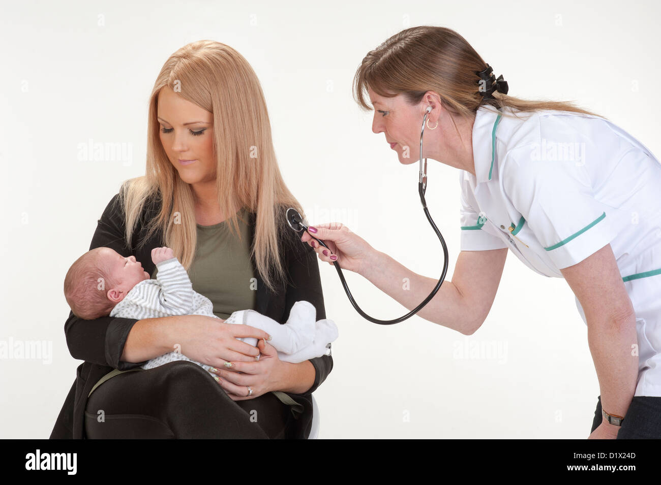 New mother holding her baby girl during postnatal medical examination ...