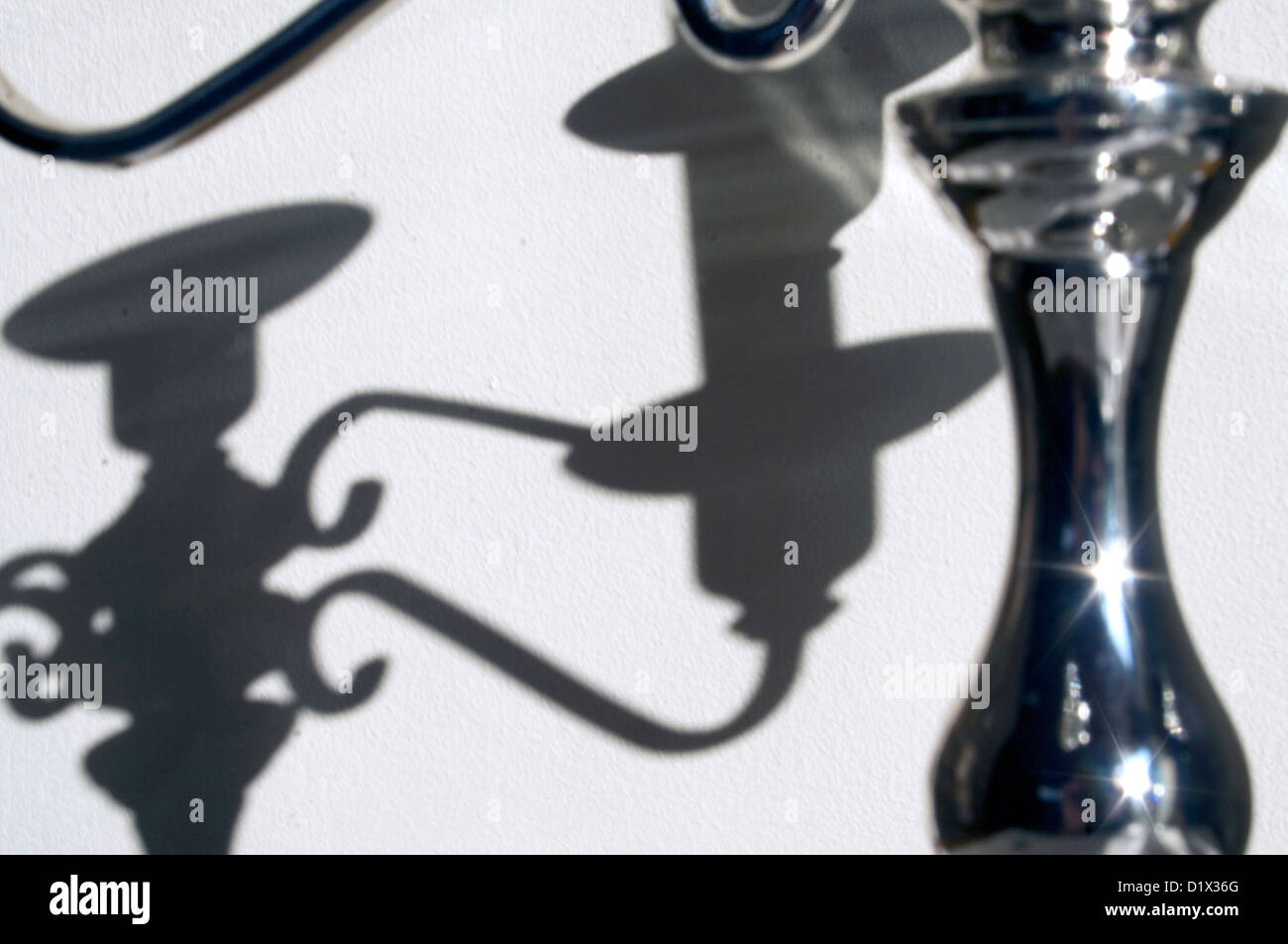 Candles in a candelabra and its shadow on the wall Stock Photo - Alamy