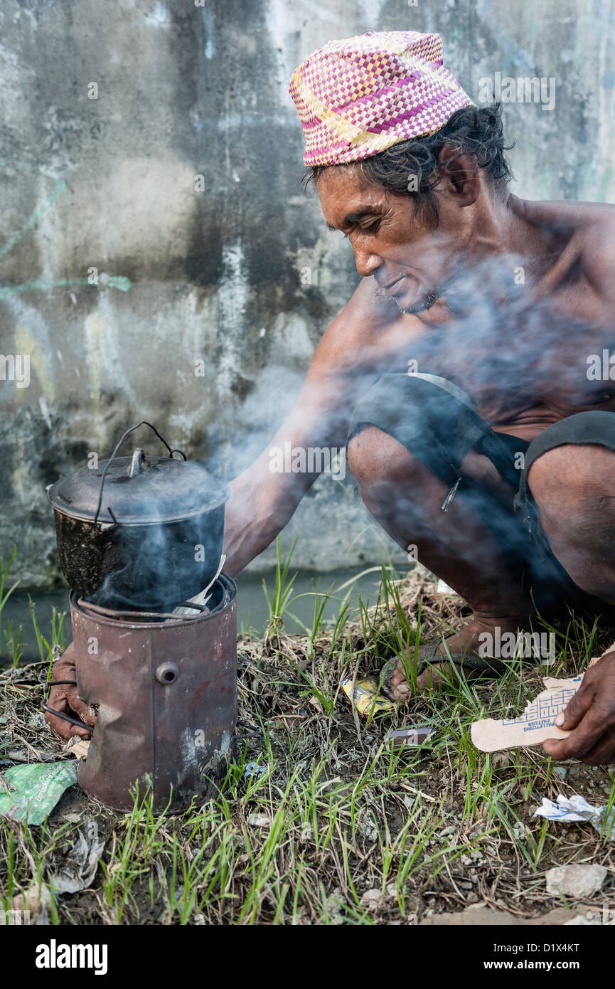 Homeless man cooking in the streets of Cebu, Visayas, Philippines ...