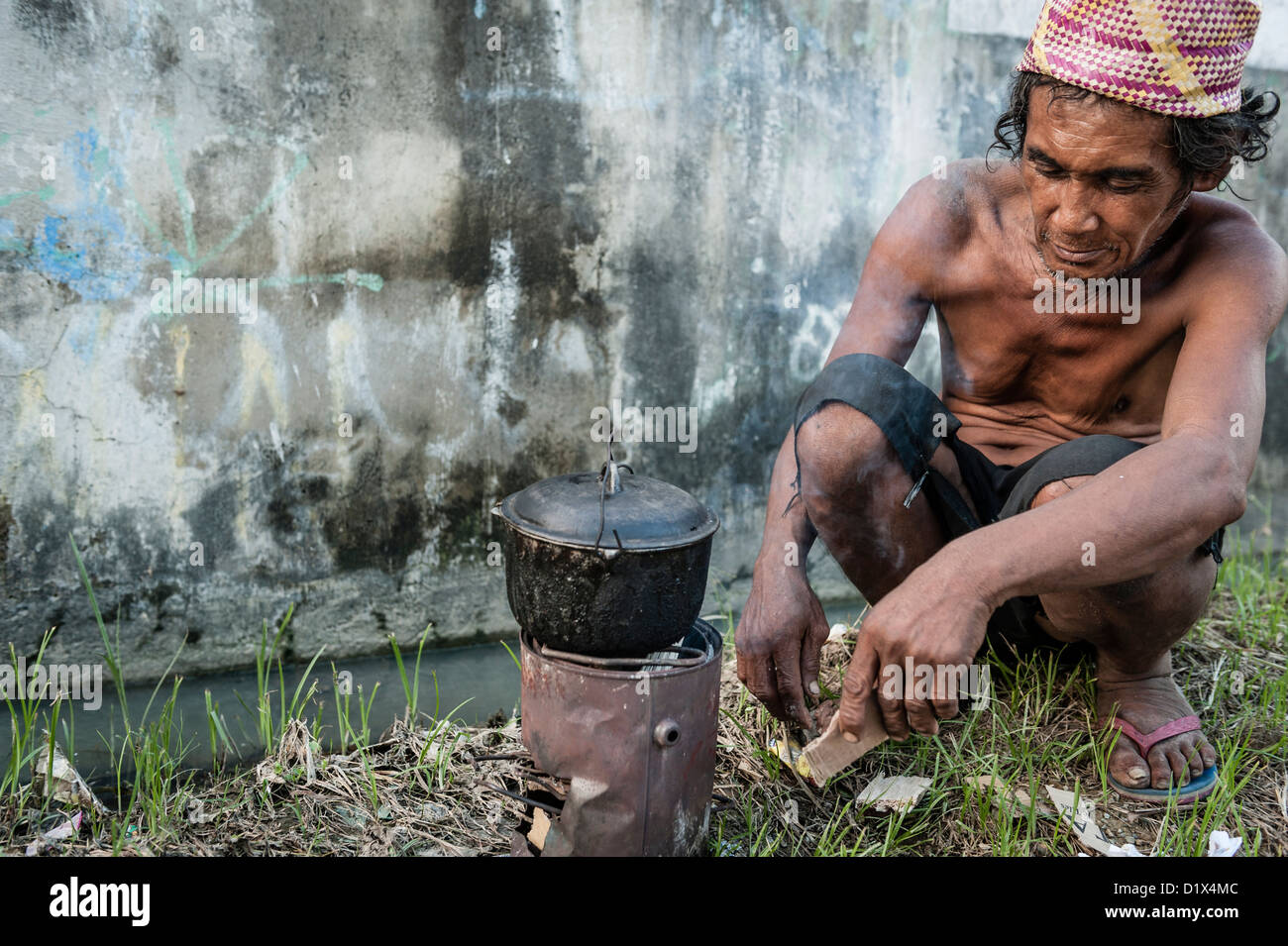 Homeless man cooking in the streets of Cebu, Visayas, Philippines ...