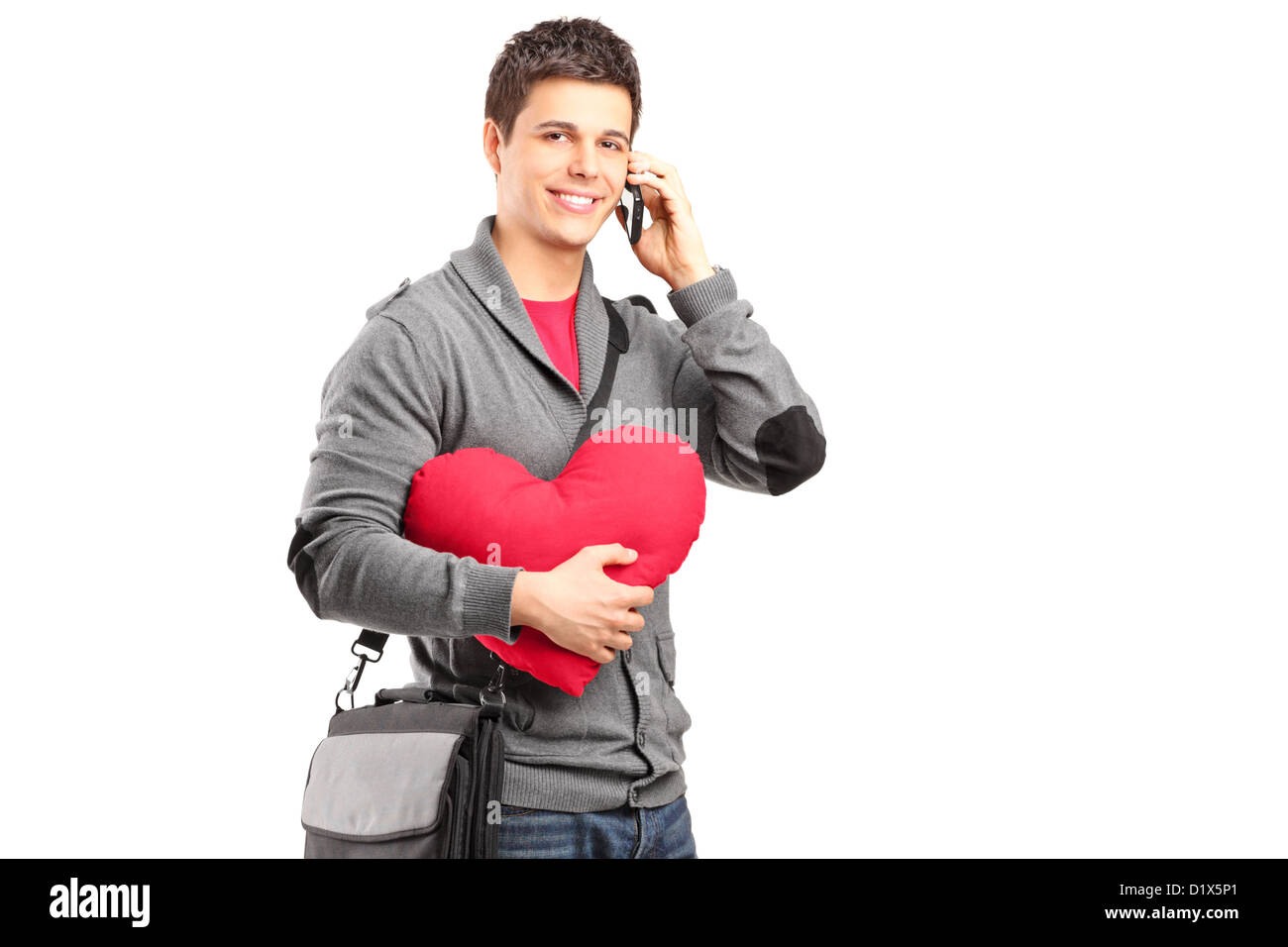 A smiling student holding a red heart and talking on a phone isolated ...