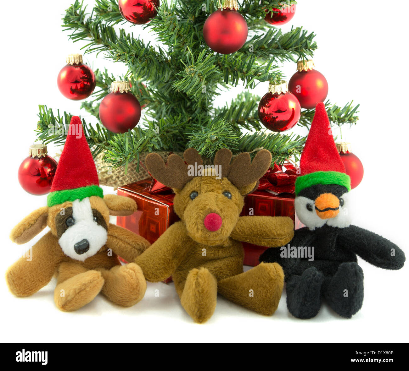 Cuddly reindeer penguin and dog sat under the christmas tree Stock ...
