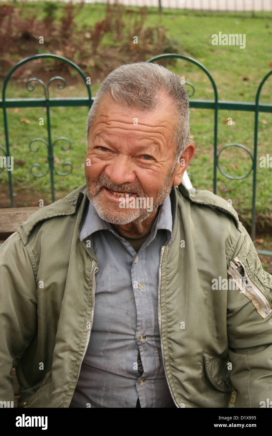 A senior citizen sitting on a park bench smiling in Cotacachi, Ecuador ...