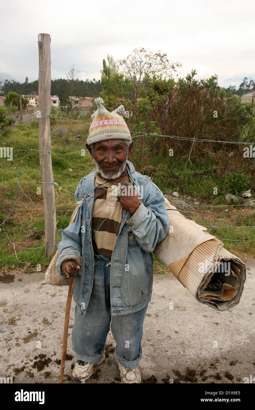A homeless Hispanic man with a knit hat and carrying cardboard on the ...
